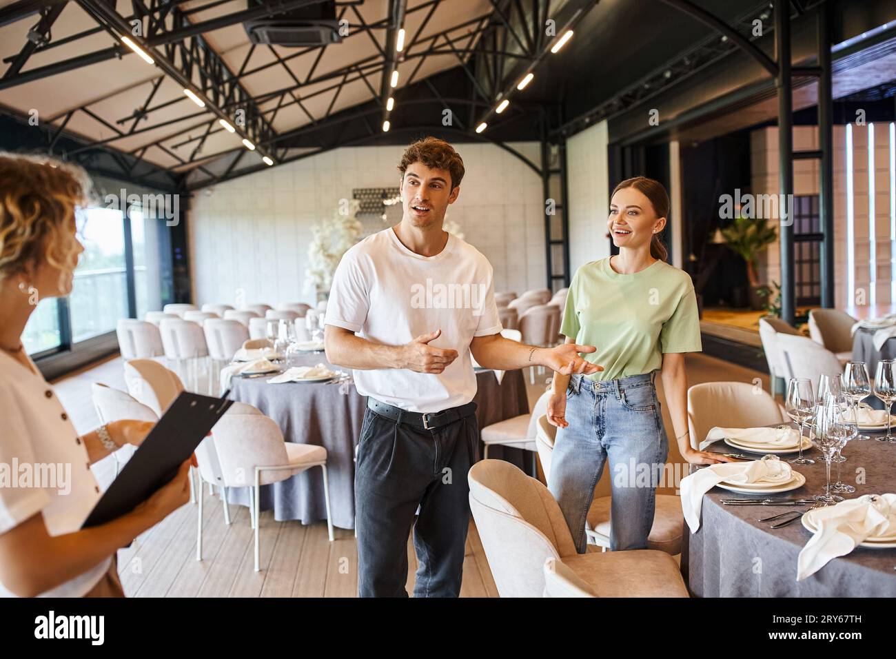decorator pointing at table near smiling colleague and team lead with ...
