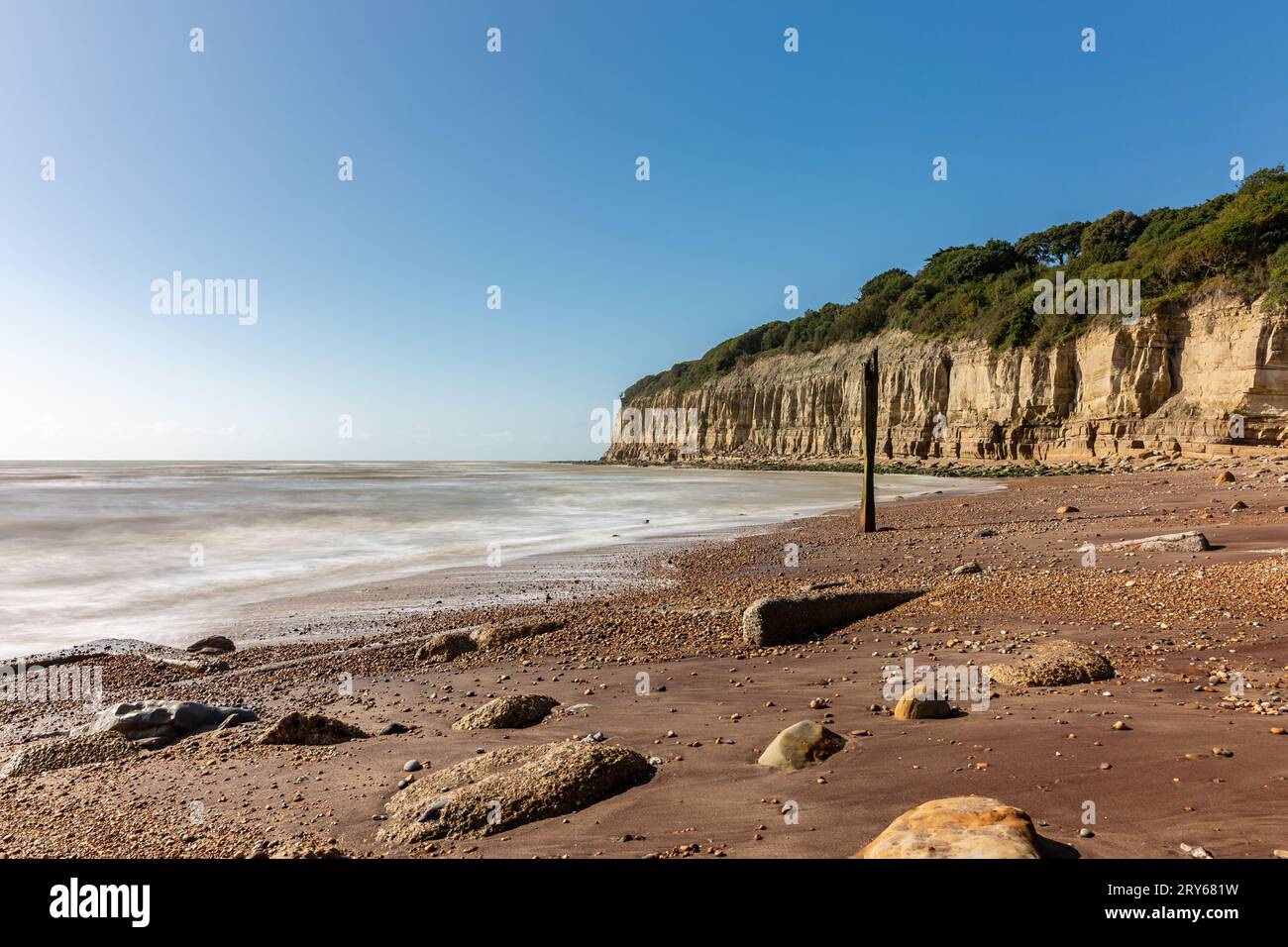 The beach at Pett Level on the Sussex coast, with a blue sky overhead ...