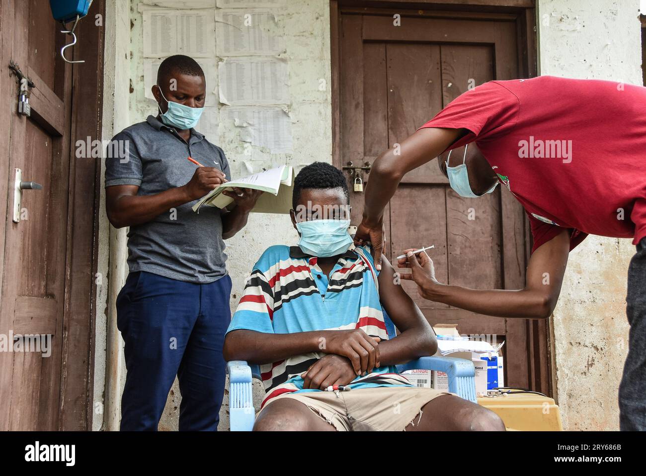 A healthcare worker, Yumbu Holela (right) injects a dose of Sinopharm ...