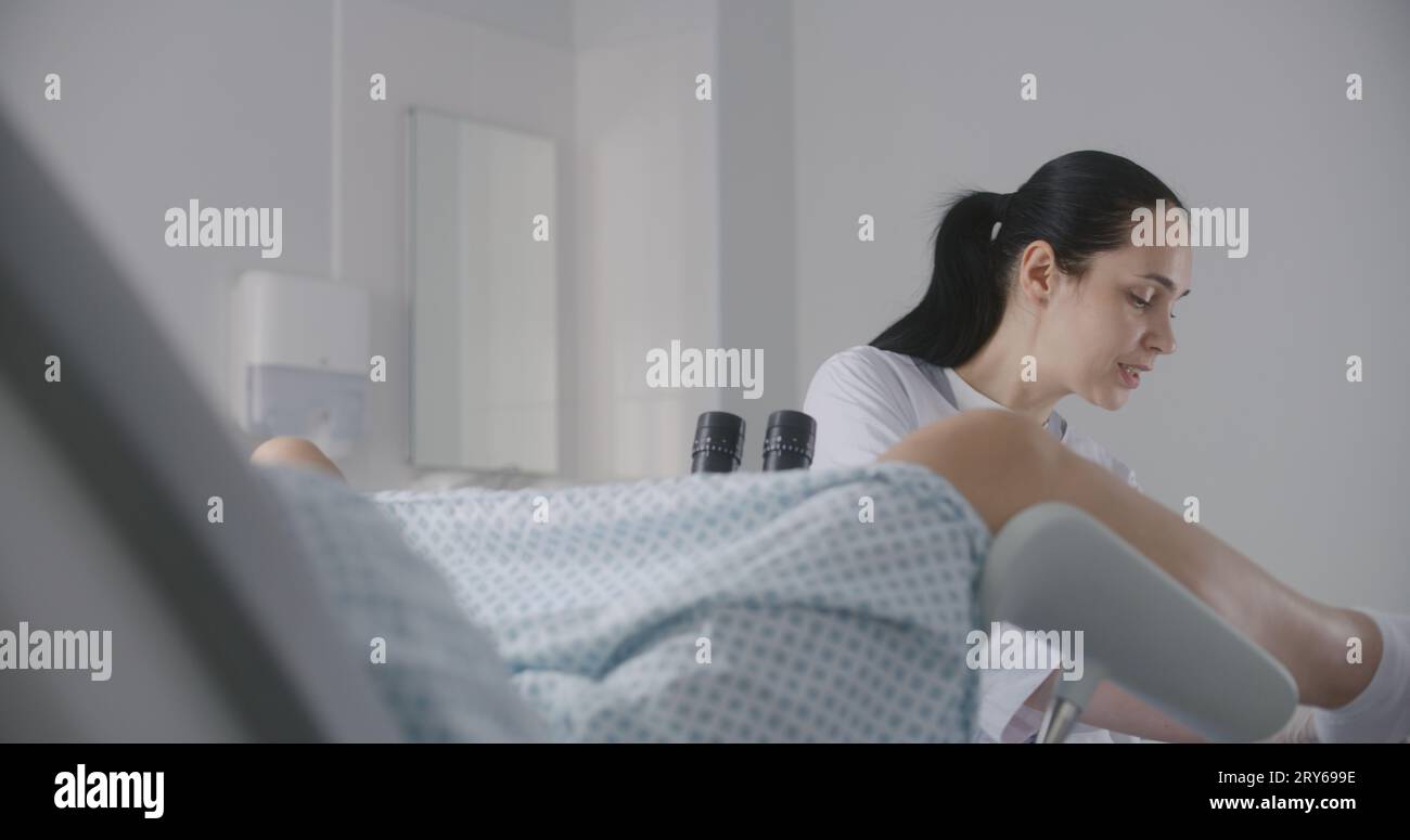 Gynecology room in hospital. Female gynecologist uses colposcope, takes ...