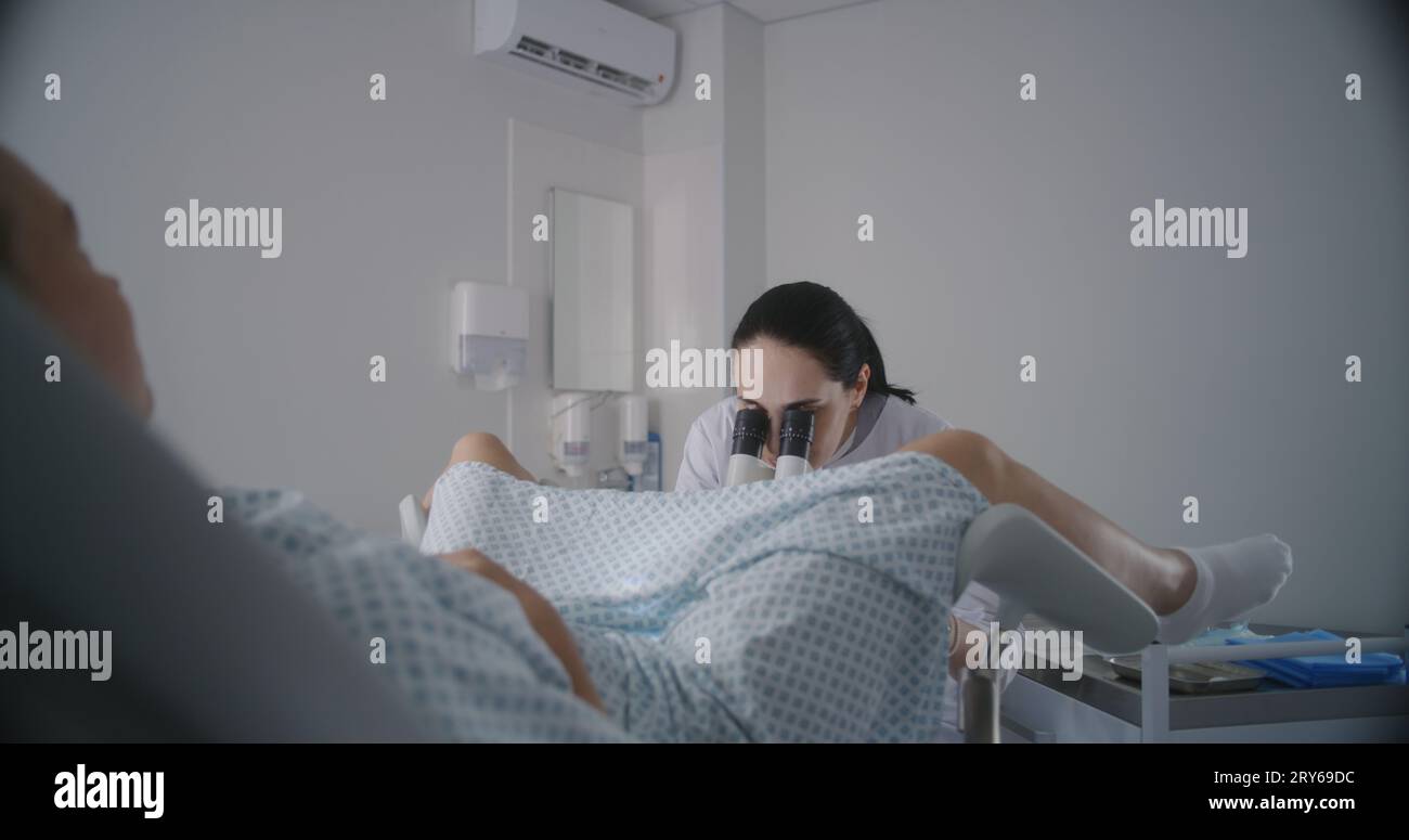 Gynecology room in hospital. Female gynecologist uses colposcope, takes ...