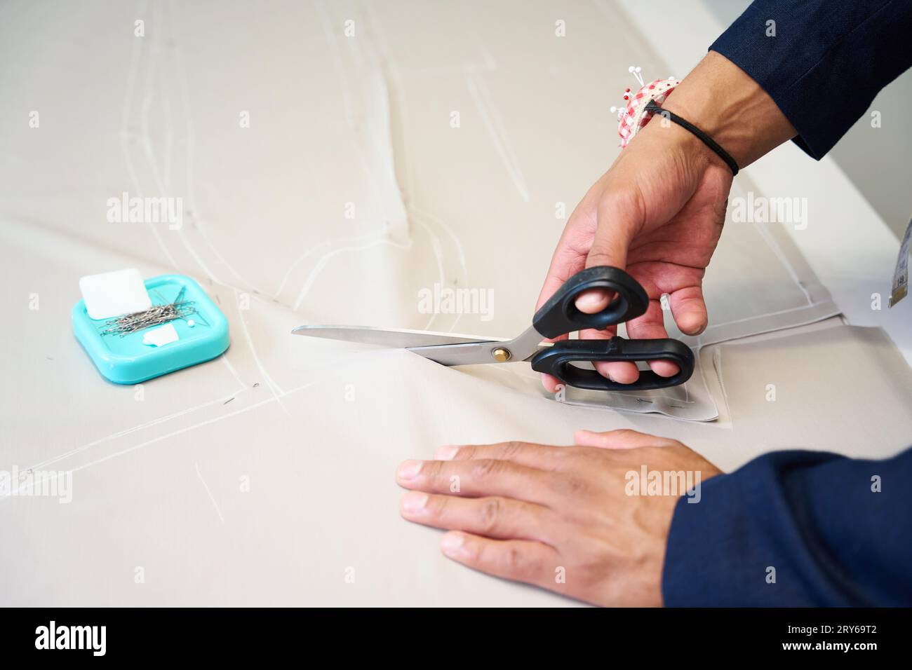 Tailor cutting pattern pieces out of fabric Stock Photo - Alamy