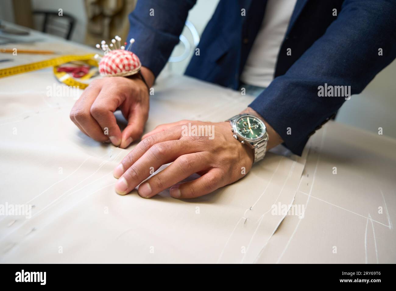 Clothier pinning pieces of fabric patterns along chalk lines Stock ...