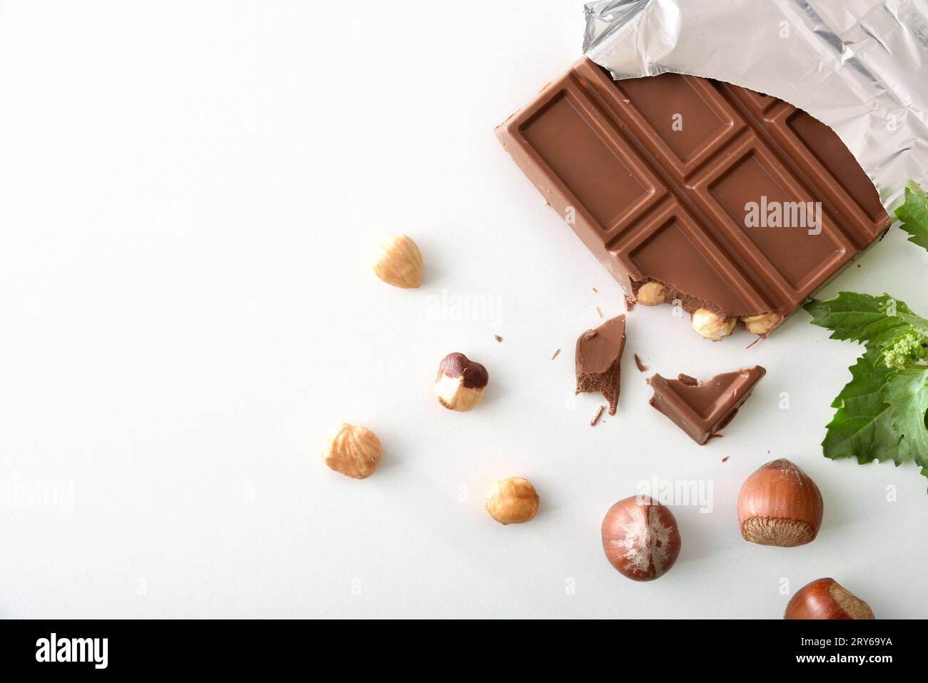 Detail of milk chocolate bar with hazelnuts in aluminum wrapper on ...