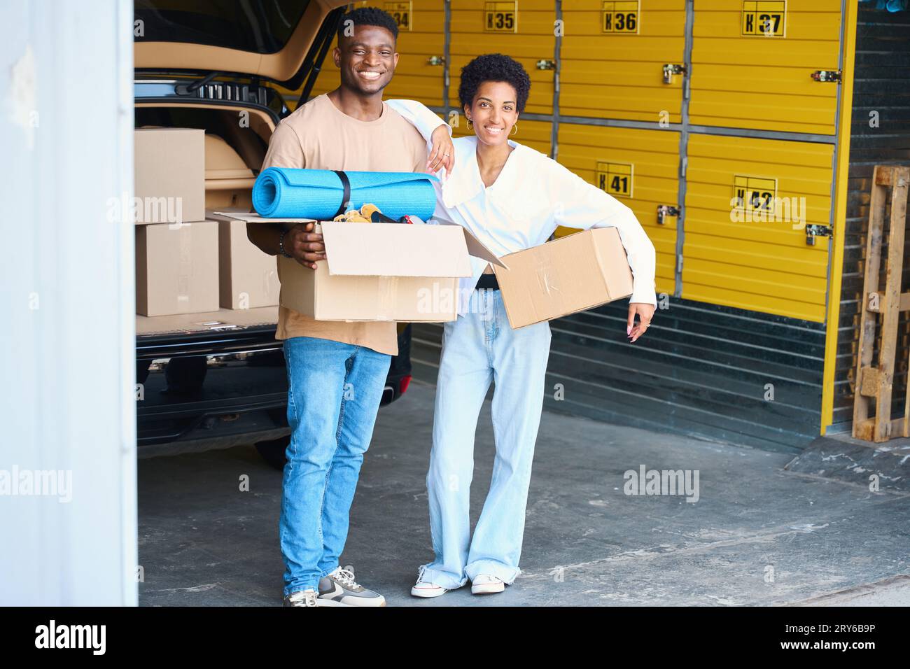 Charming woman with a friend with boxes in storage room Stock Photo - Alamy