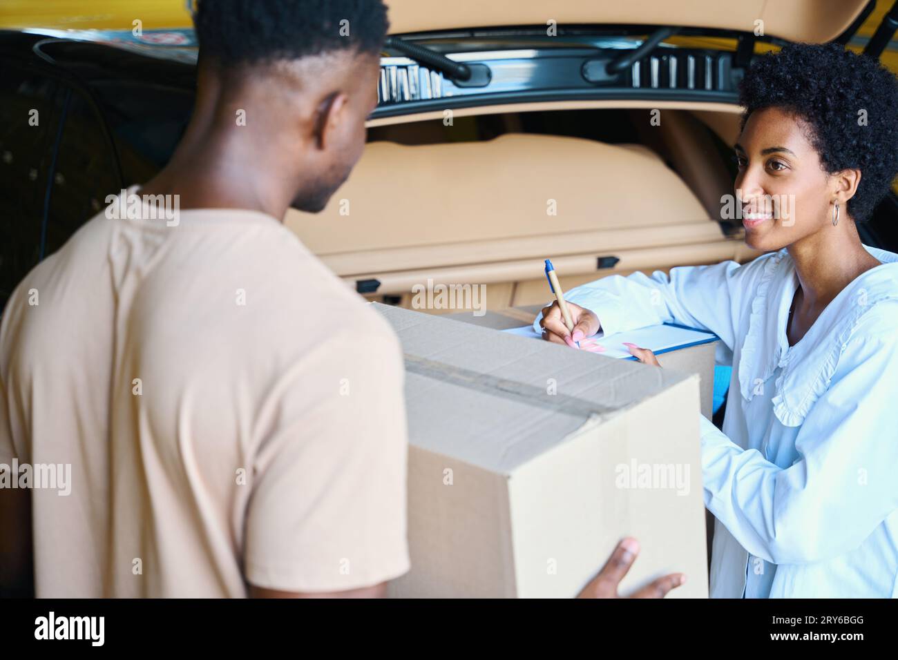 Cute African American woman making inventory of things being deposited ...