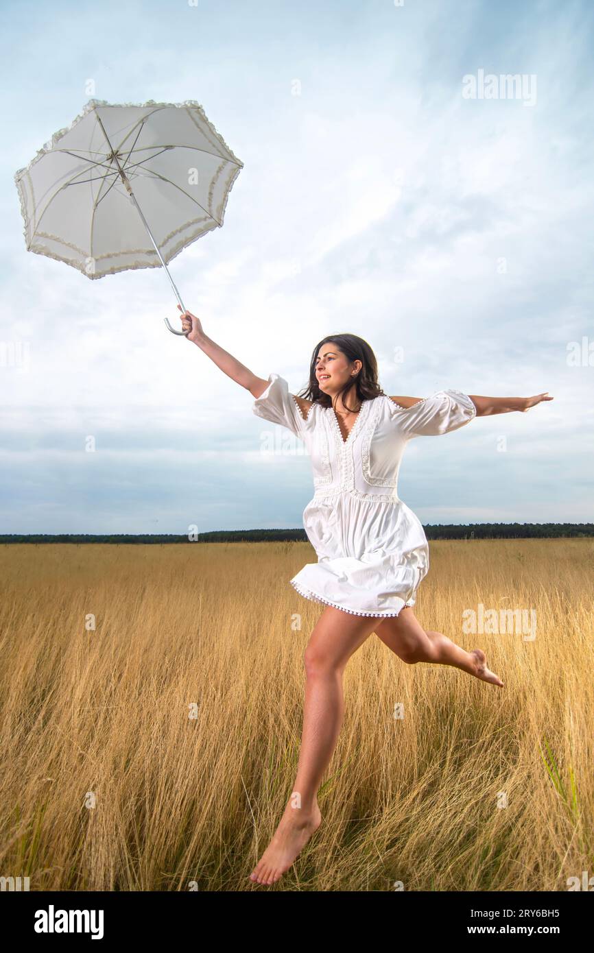 Young girl jumping with happiness exuberantly with umbrella Stock Photo ...