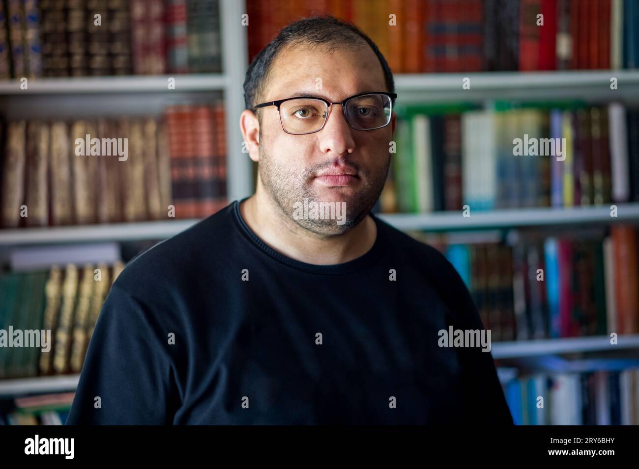 Portrait for male wearing glasses in library wearing black shirts with ...