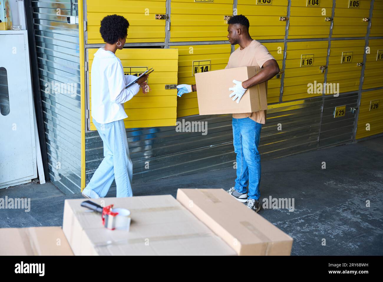 African American guy loads a cardboard box into storage unit Stock ...