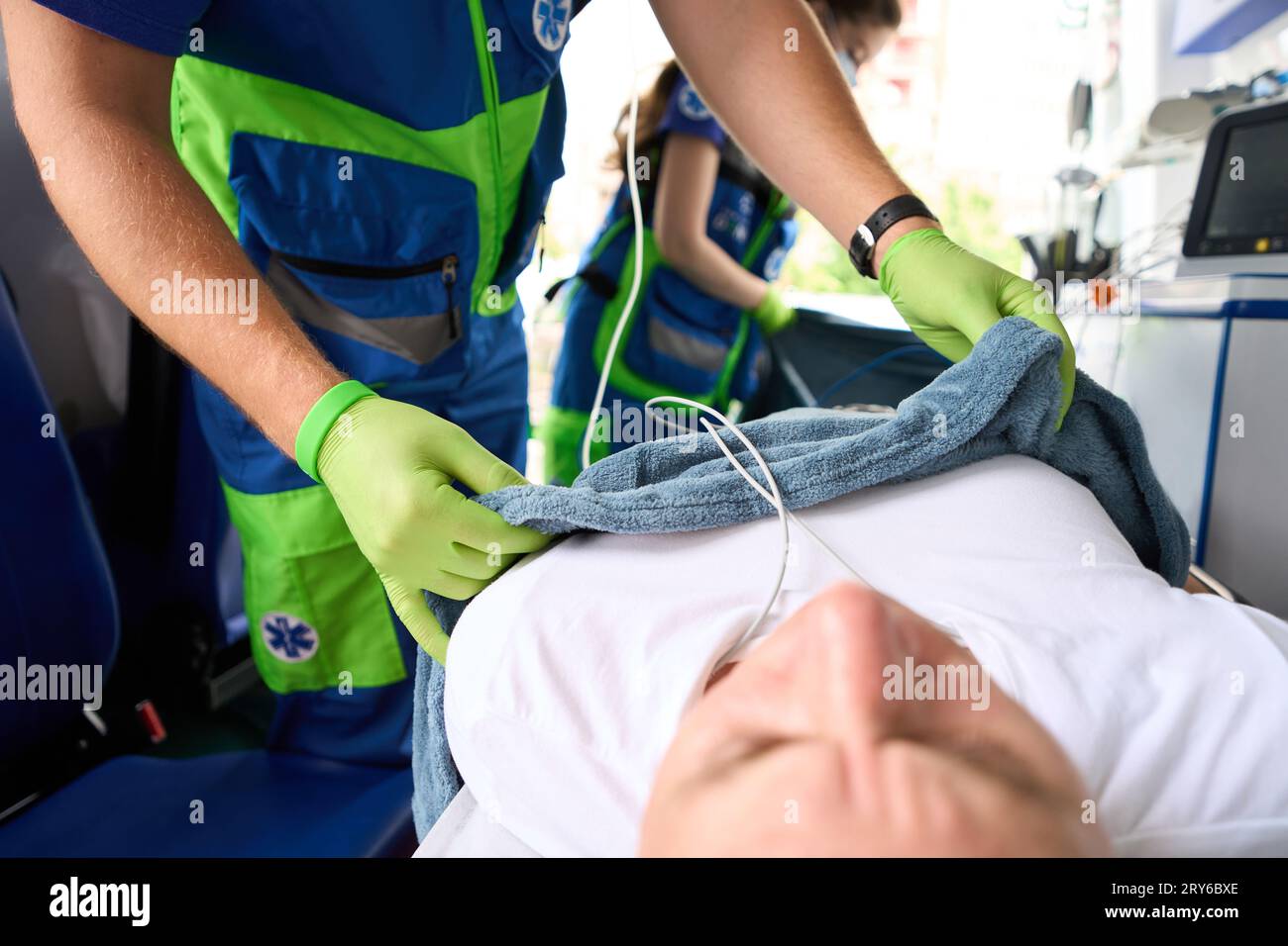 Medic covers a patient with a soft blanket in ambulance Stock Photo - Alamy