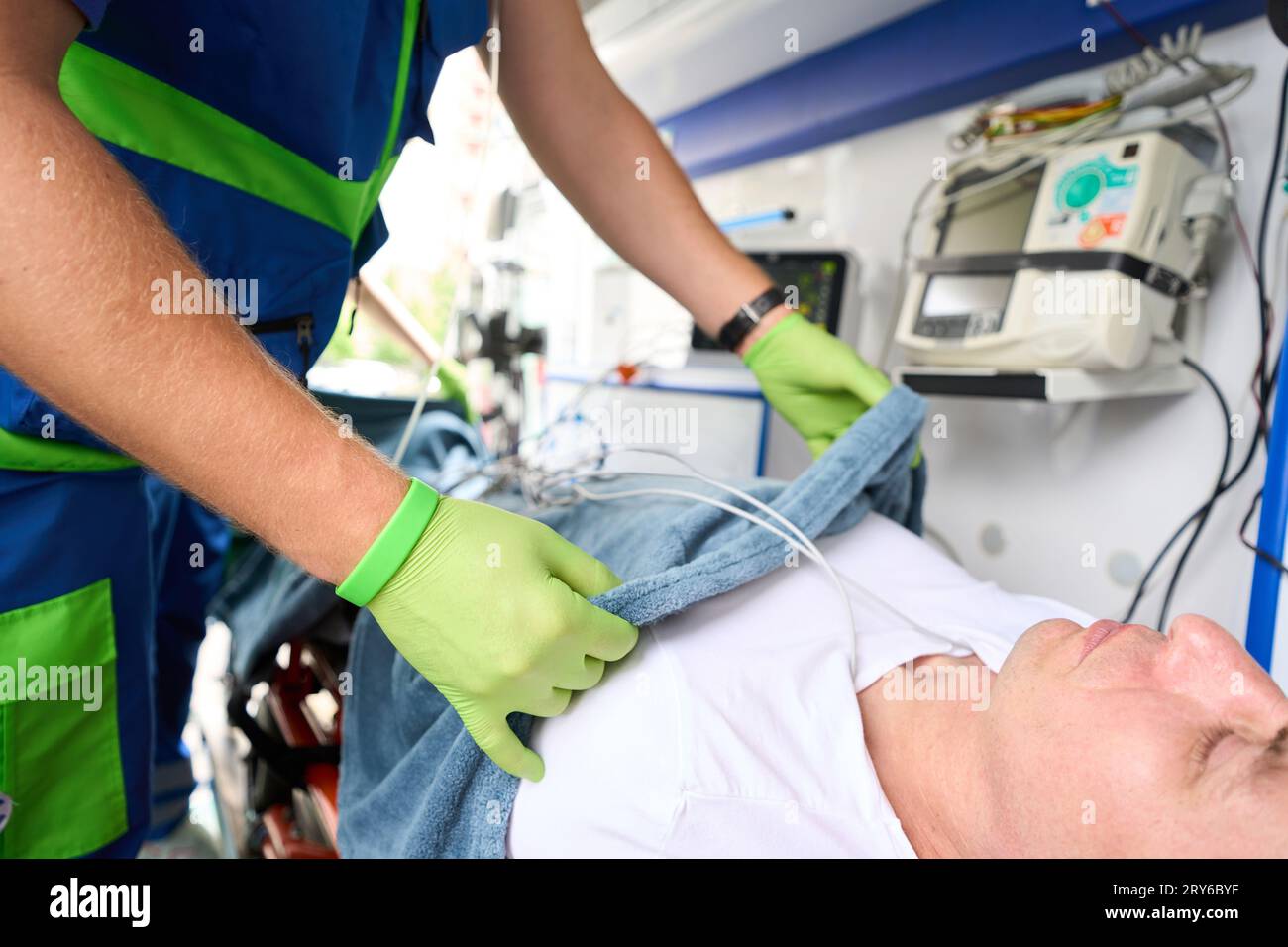 Paramedic covers a patient with a soft blanket in ambulance Stock Photo ...