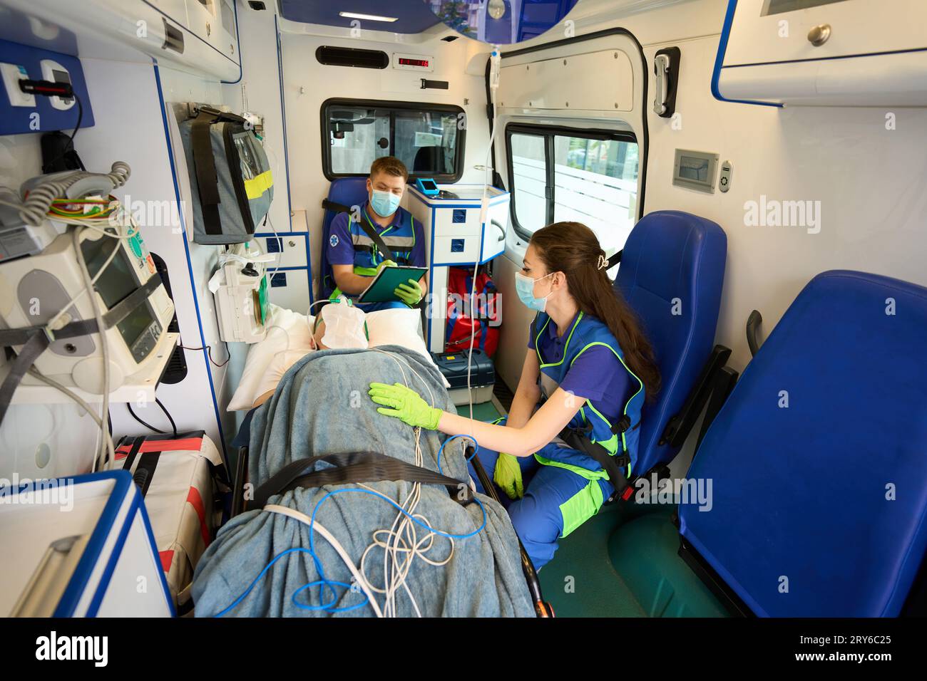 Doctors of mobile team transport patient in oxygen mask in ambulance ...