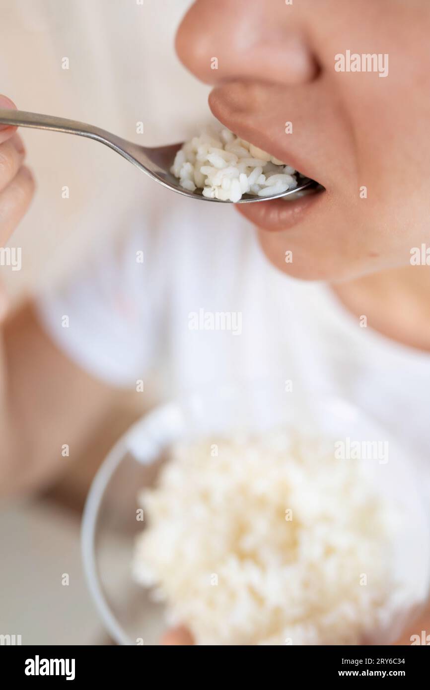 Woman puts spoon rice hi-res stock photography and images - Alamy