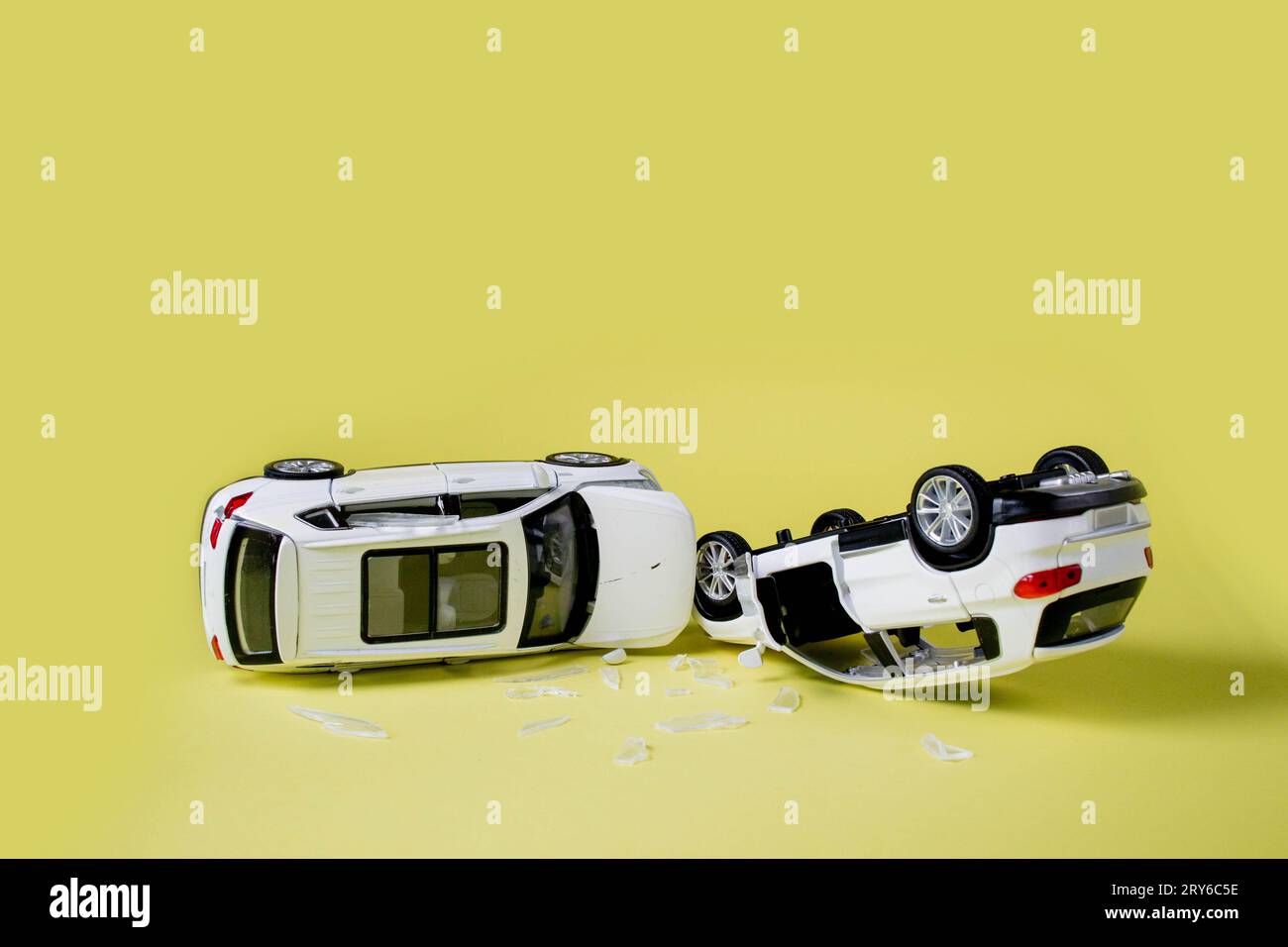 Two mini toy car crash on yellow background, incident, car traffic ...