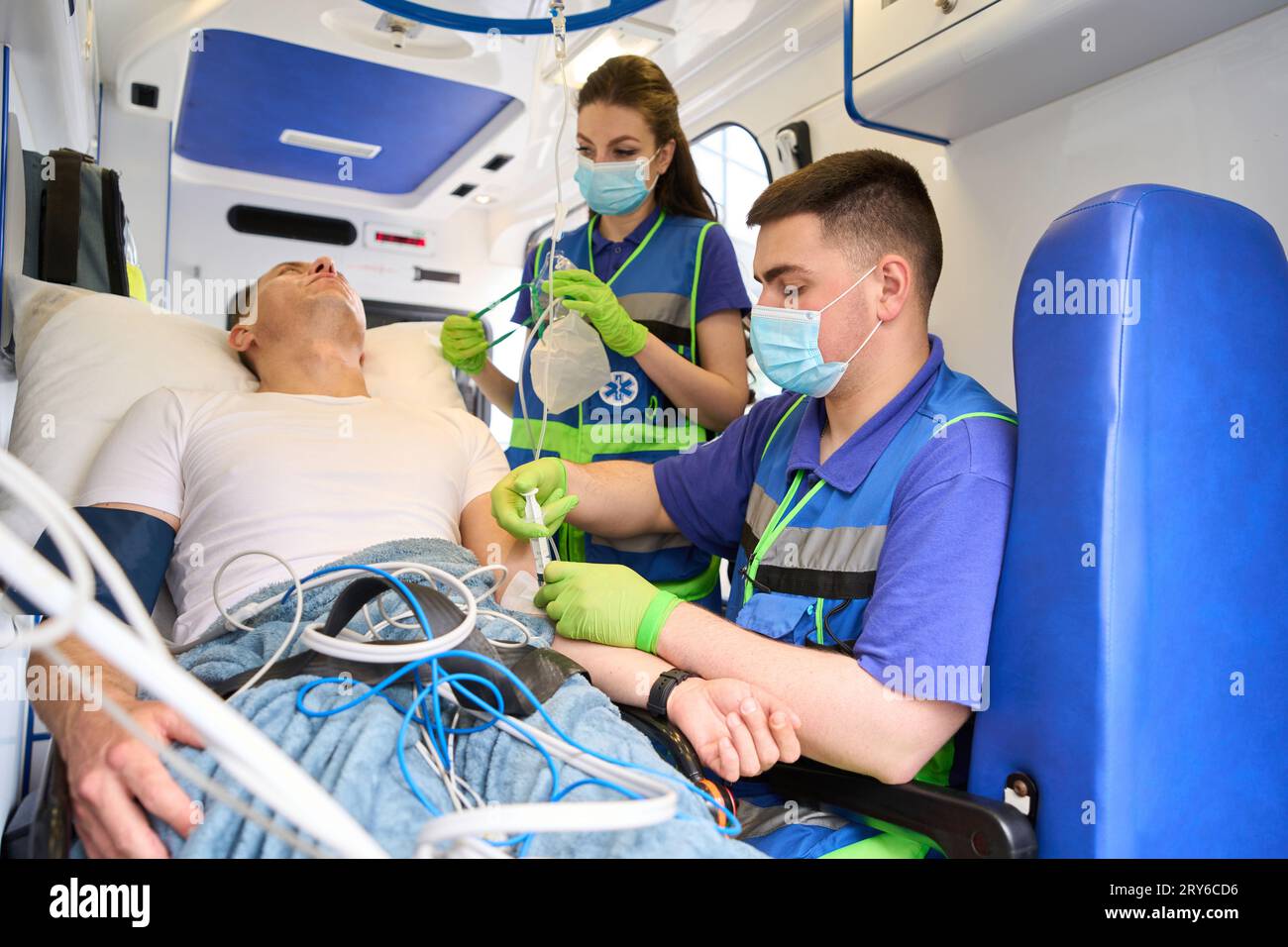 Mobile medical team connects a patient to a drip in an ambulance Stock ...