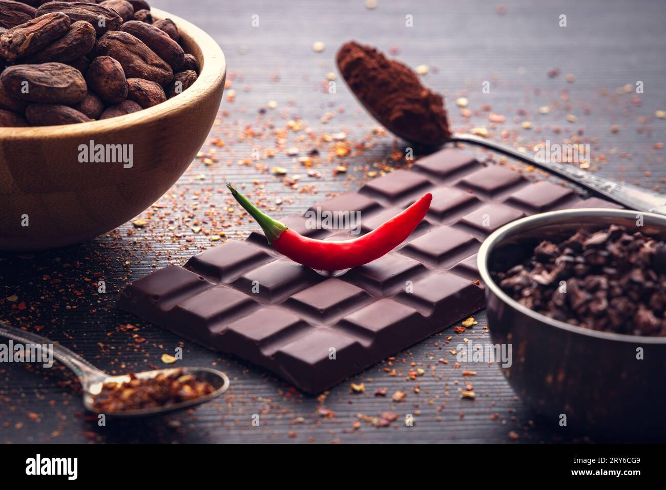 Dark chocolate bar, red hot chilli pepper cayenne, dry hot chili spices, cocoa beans nibs powder ...