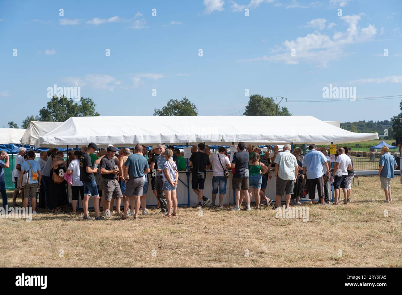 Farmers gather around the bar at a harvest festival Stock Photo - Alamy