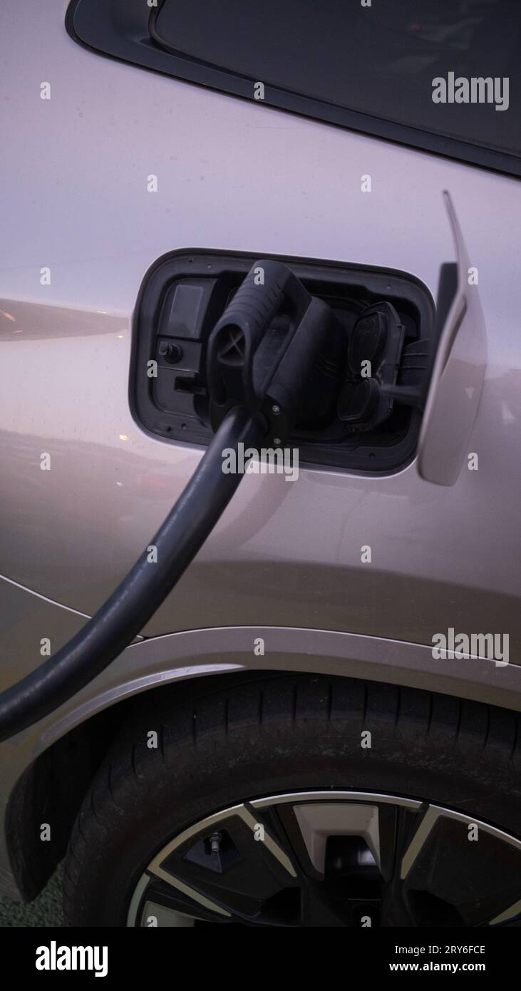 Power cable pump plug in charging power to electric vehicle EV car with ...