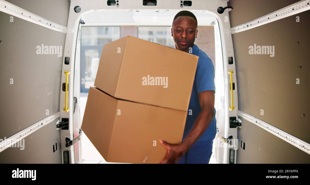 Young Delivery Men Loading Cardboard Boxes In Truck Stock Photo - Alamy