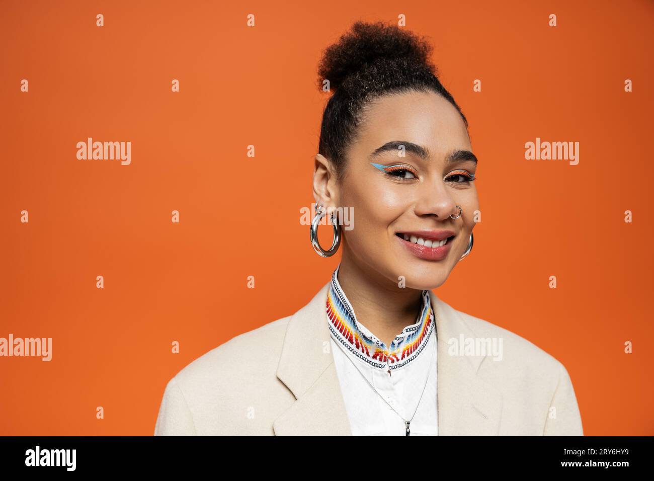 close up happy fashion model with hoop earrings looking and smiling at ...