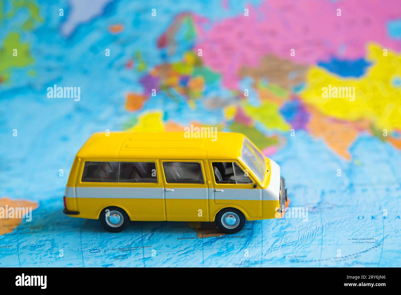 Yellow bus on satin. World map, close-up Stock Photo - Alamy