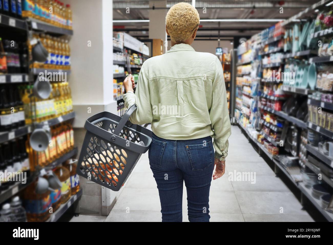 Back, supermarket shopping and a woman customer in a store to purchase ...