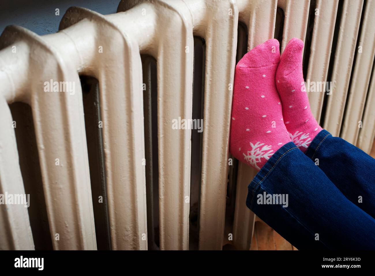 Female warming up her feet on central heating radiator Stock Photo - Alamy