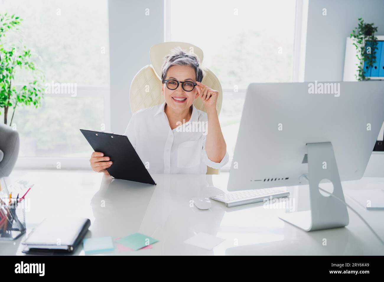 Photo of charming positive lady assistant wear white shirt reading ...