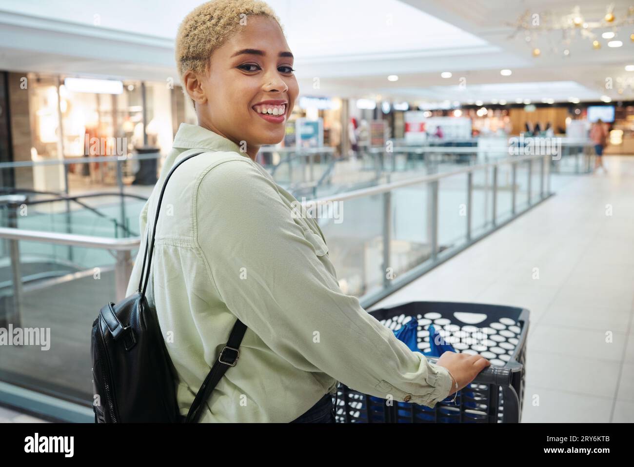 Portrait, shopping cart and happy woman in mall, retail supermarket and ...