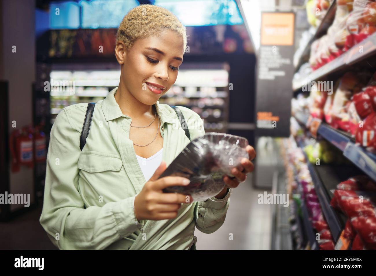 Woman, grocery shopping and price check with smile, food and produce ...