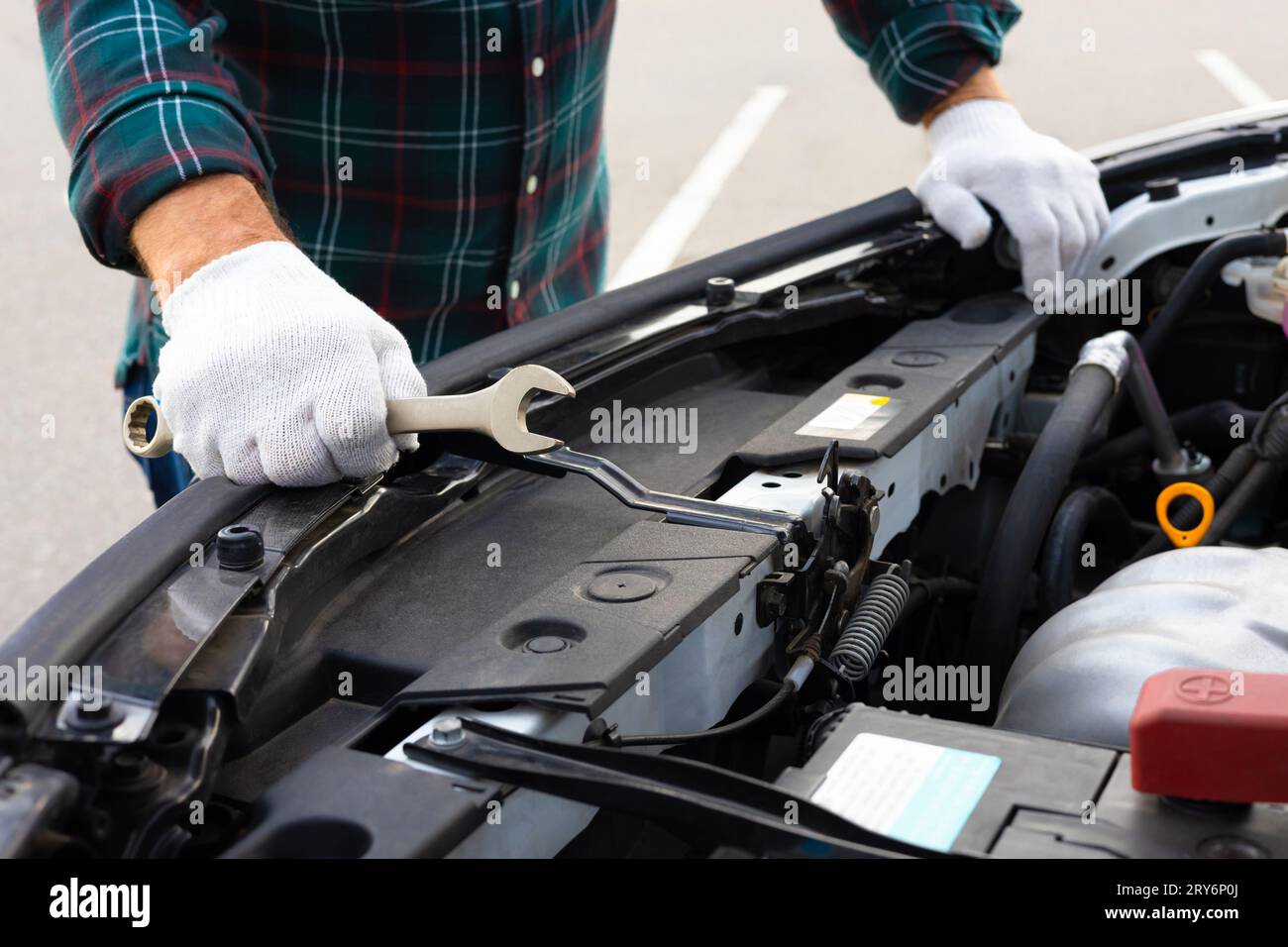 the driver inspects the engine compartment of the car. man with a ...