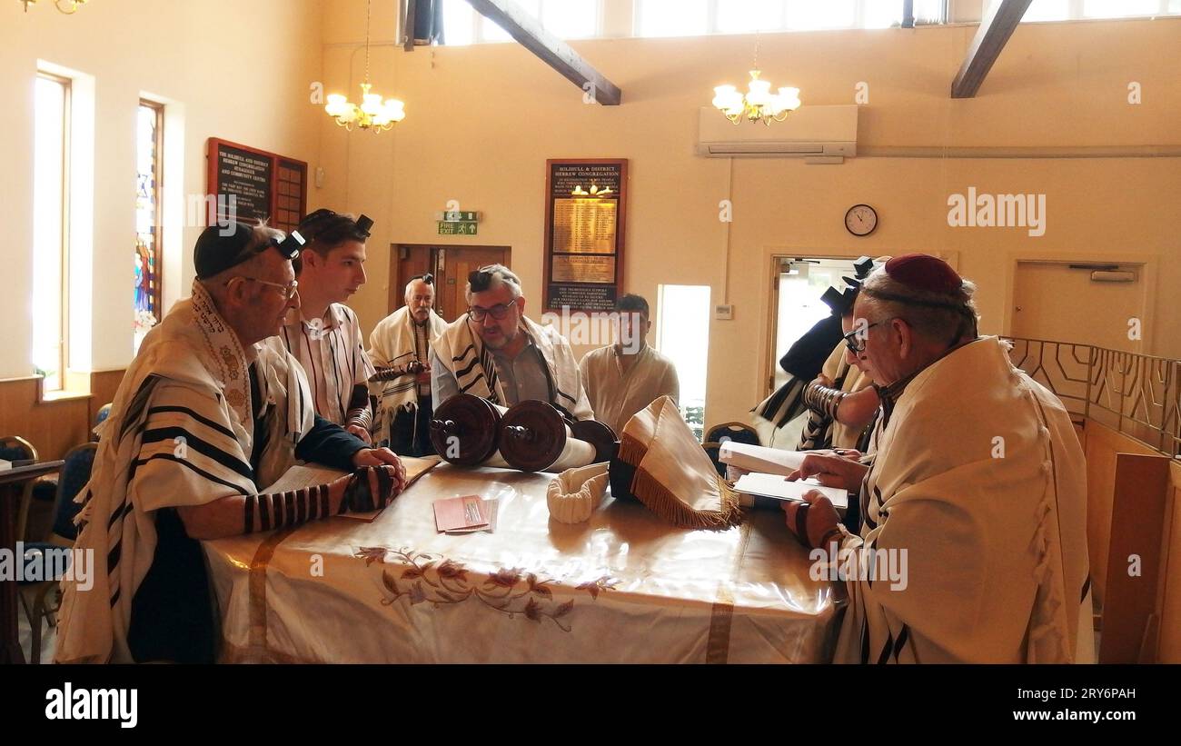 A grandfather is called up to read the Torah by the rabbi during a ...