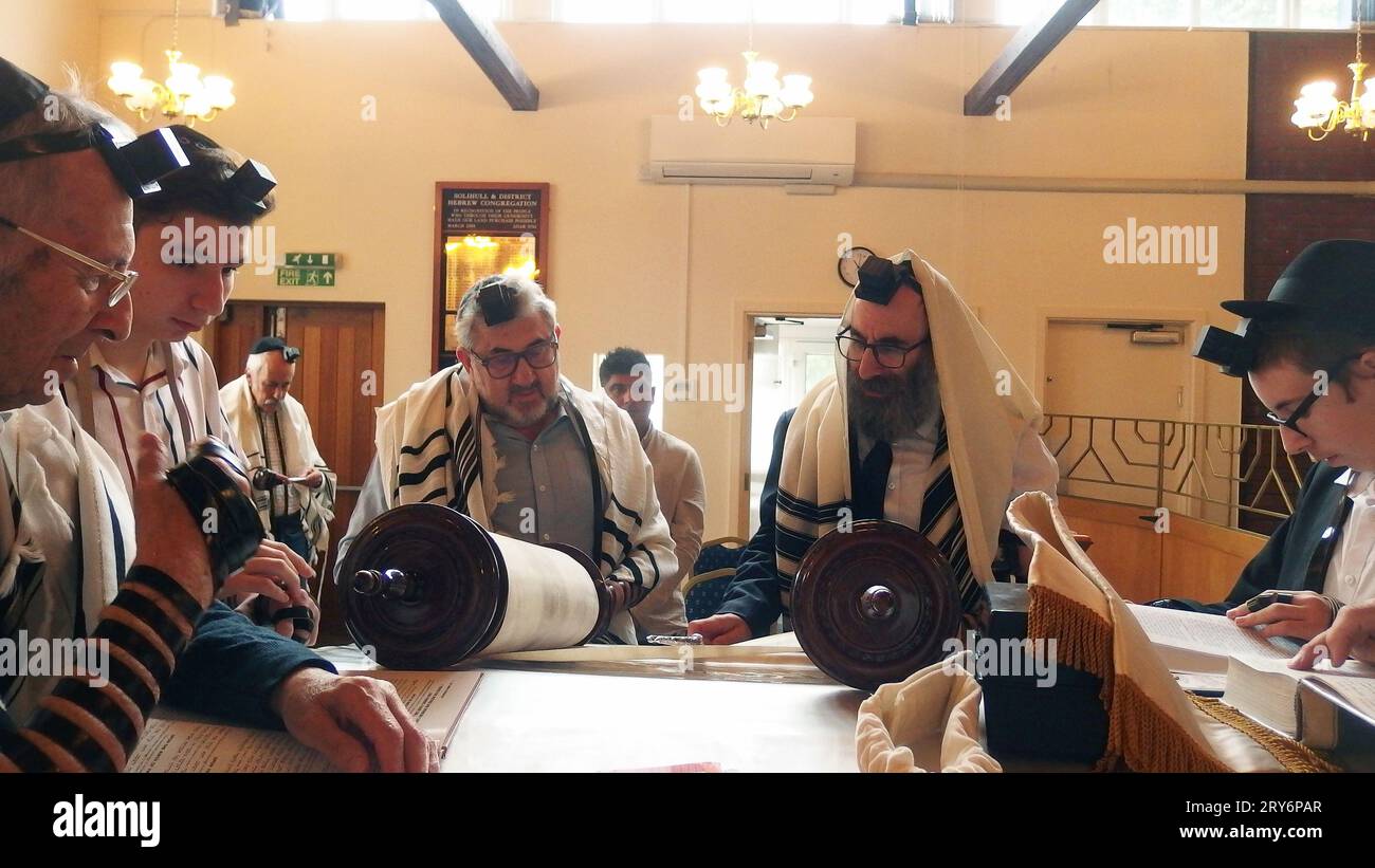 A grandfather is called up to read the Torah by the rabbi during a ...