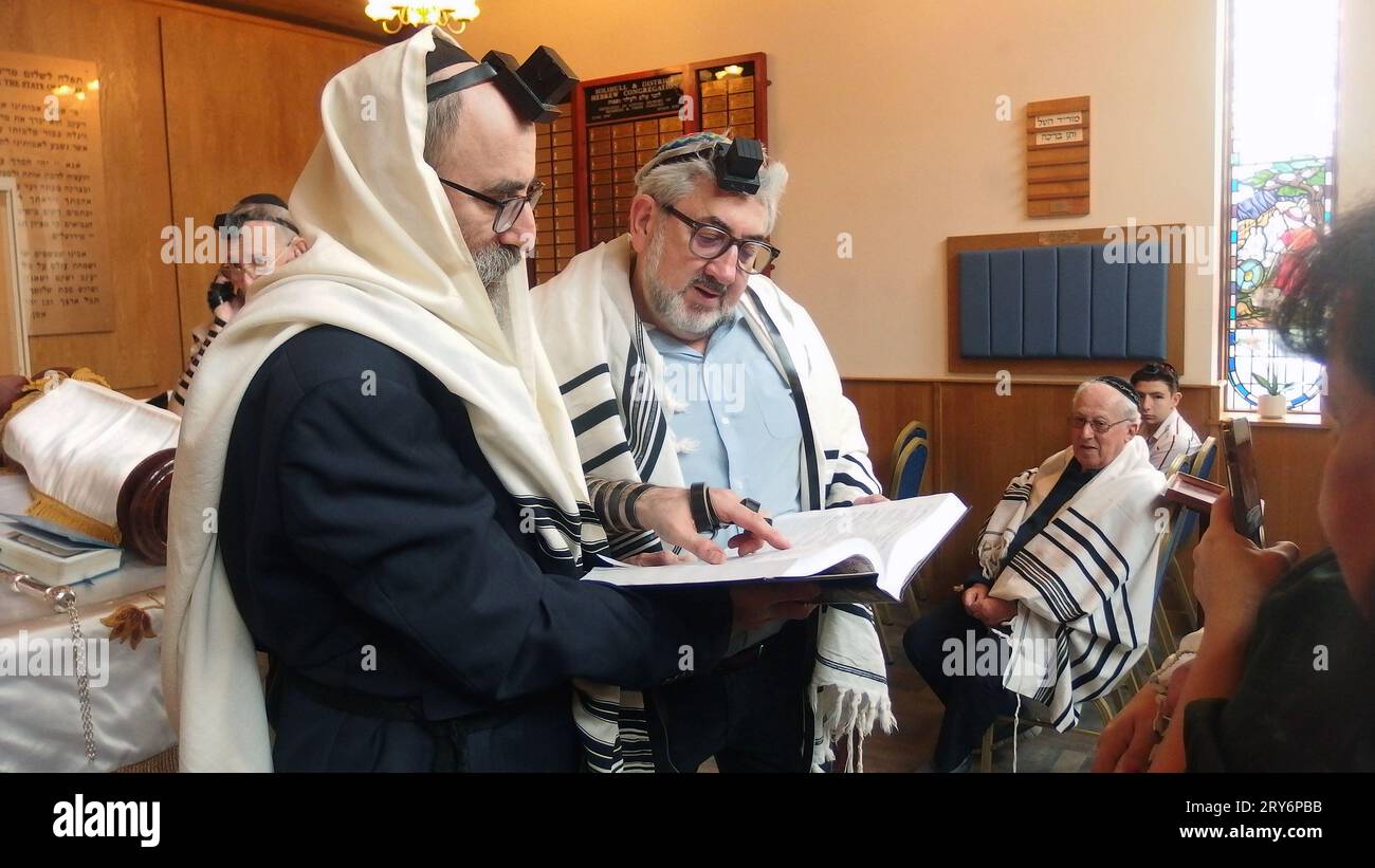 A grandfather is called up to read the Torah by the rabbi during a ...