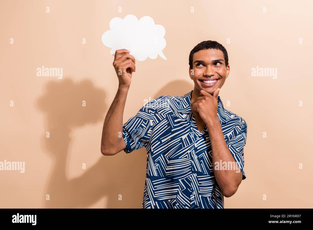 Photo portrait of handsome young guy interested touch chin paper cloud ...