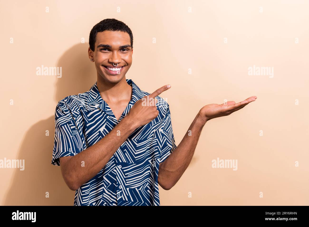 Photo of positive cheerful guy dressed print shirt showing arm pointing ...