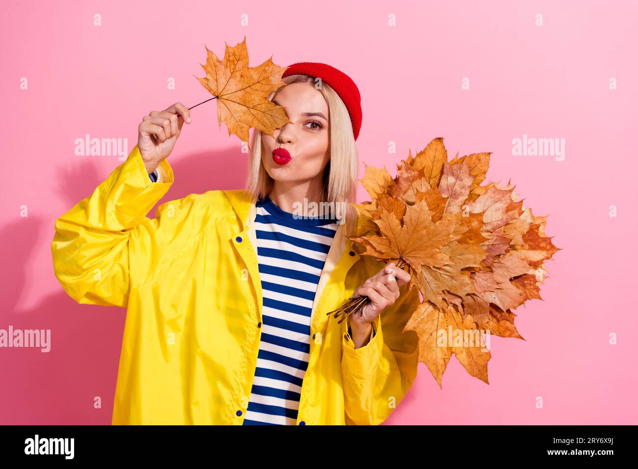 Photo of funky flirty woman dressed rain coat holding yellow leaves ...