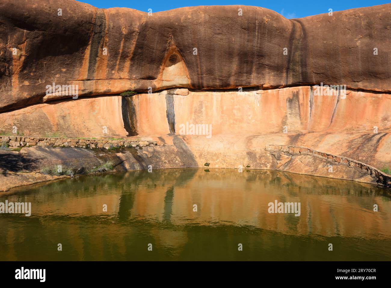 The large gnamma hole with water at the granite outcrop of ...