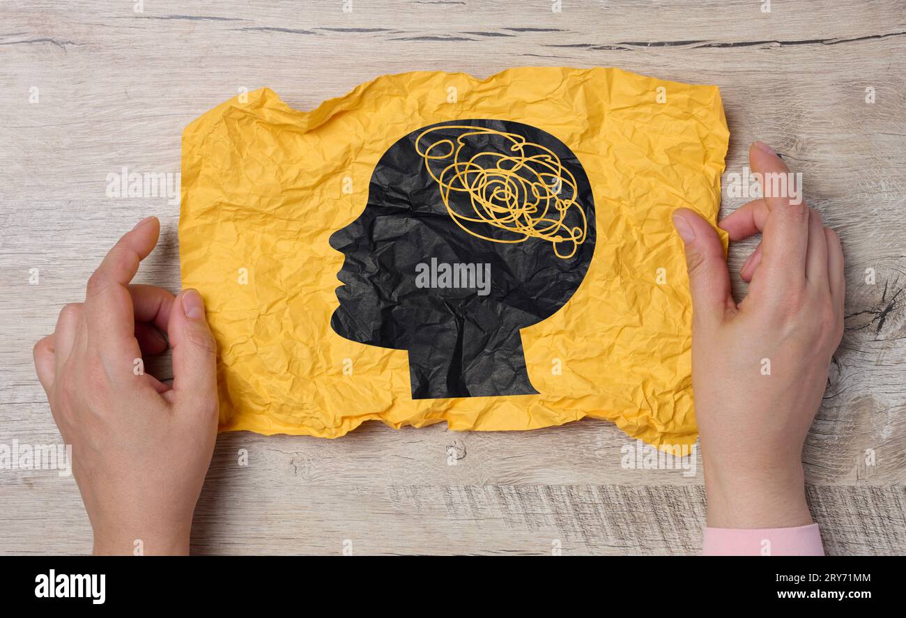 A female hand holds a crumpled paper with a black silhouette of a ...