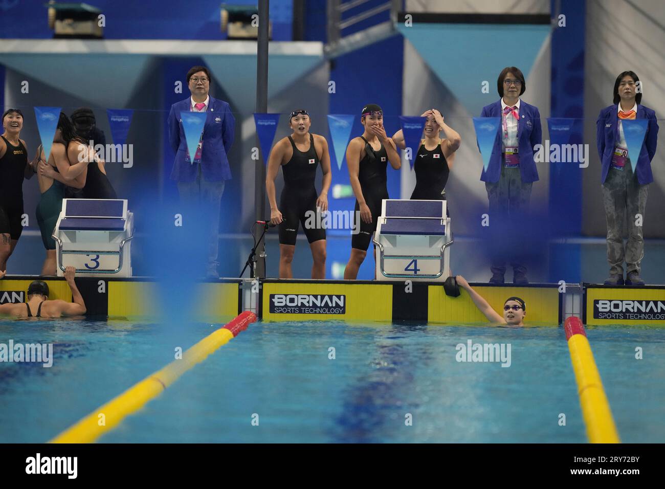 Team Japan celebrates winning gold as team Singapore, left, watches the ...