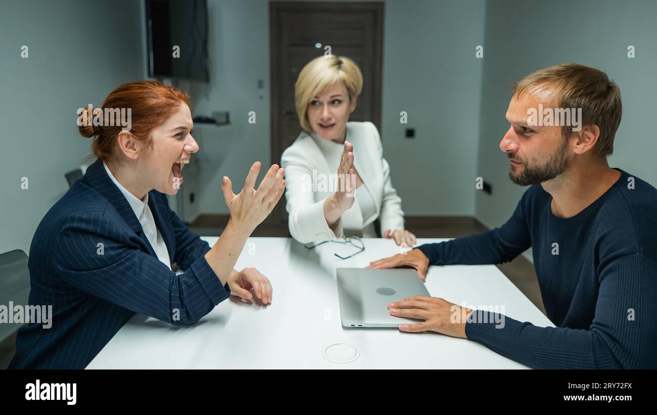 Blond, red-haired woman and bearded man in suits in the office ...