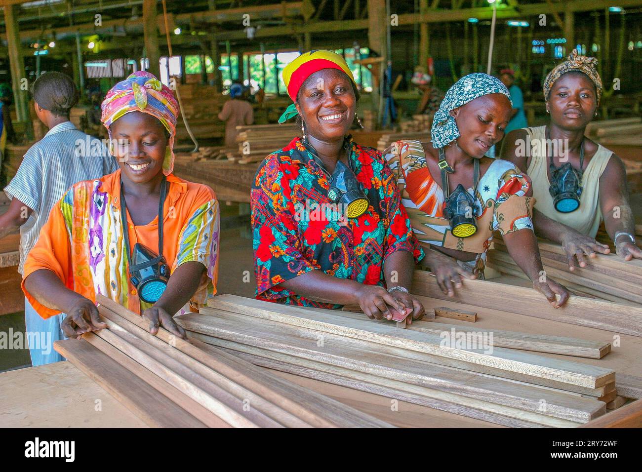 Ghana, Takoradi. Female workers of timber company sandpaper wood. The ...