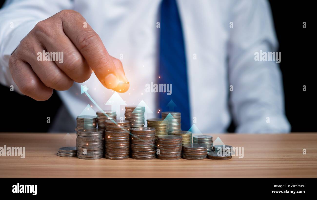 Businessman puts money on pile of coins. Ideas for investing and ...