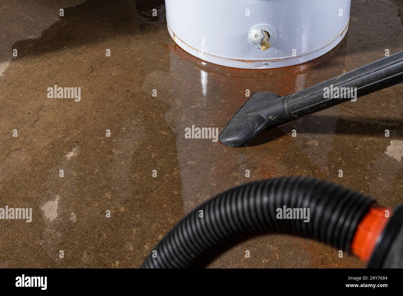 A wet-dry vacuum being used to clean up water from a leaking ...