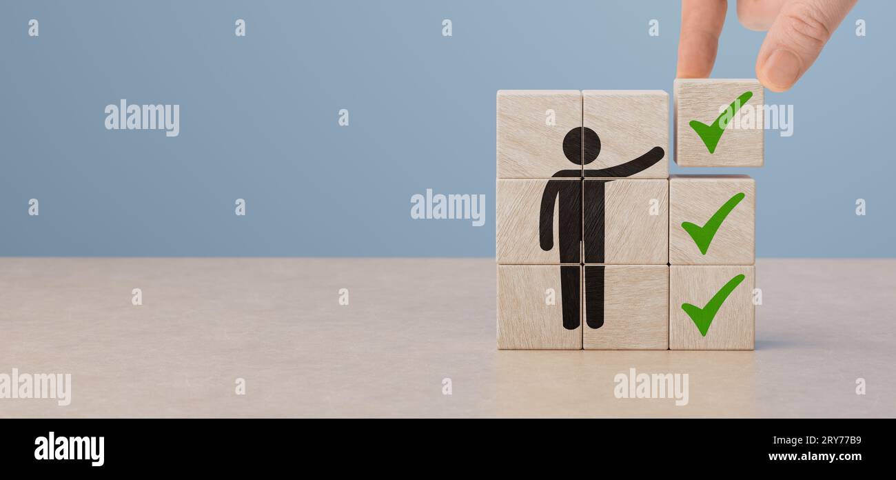 Wooden blocks checklist and green check mark icon with hand on table ...