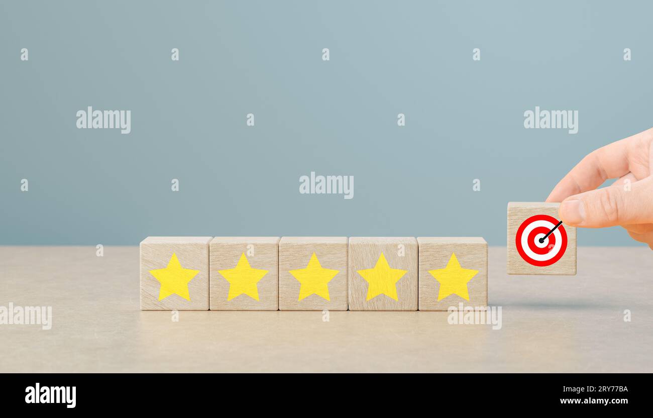goal is to achieve five-star rating. hand holding cube with target next ...