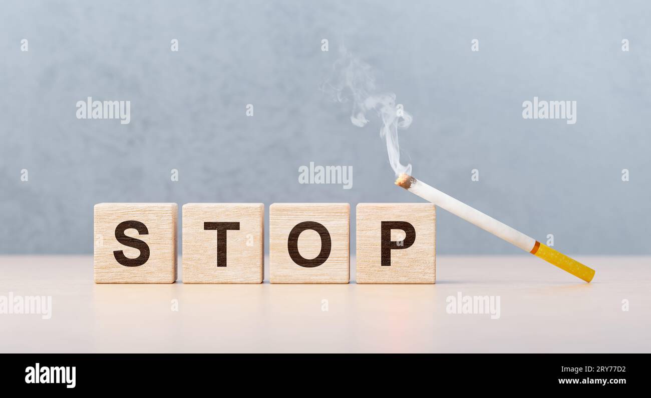 wooden cubes with inscription stop and smoking cigarette. stop smoking ...