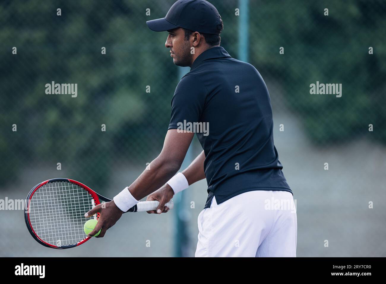 Side view of a tennis player preparing to hit the serve during a match ...