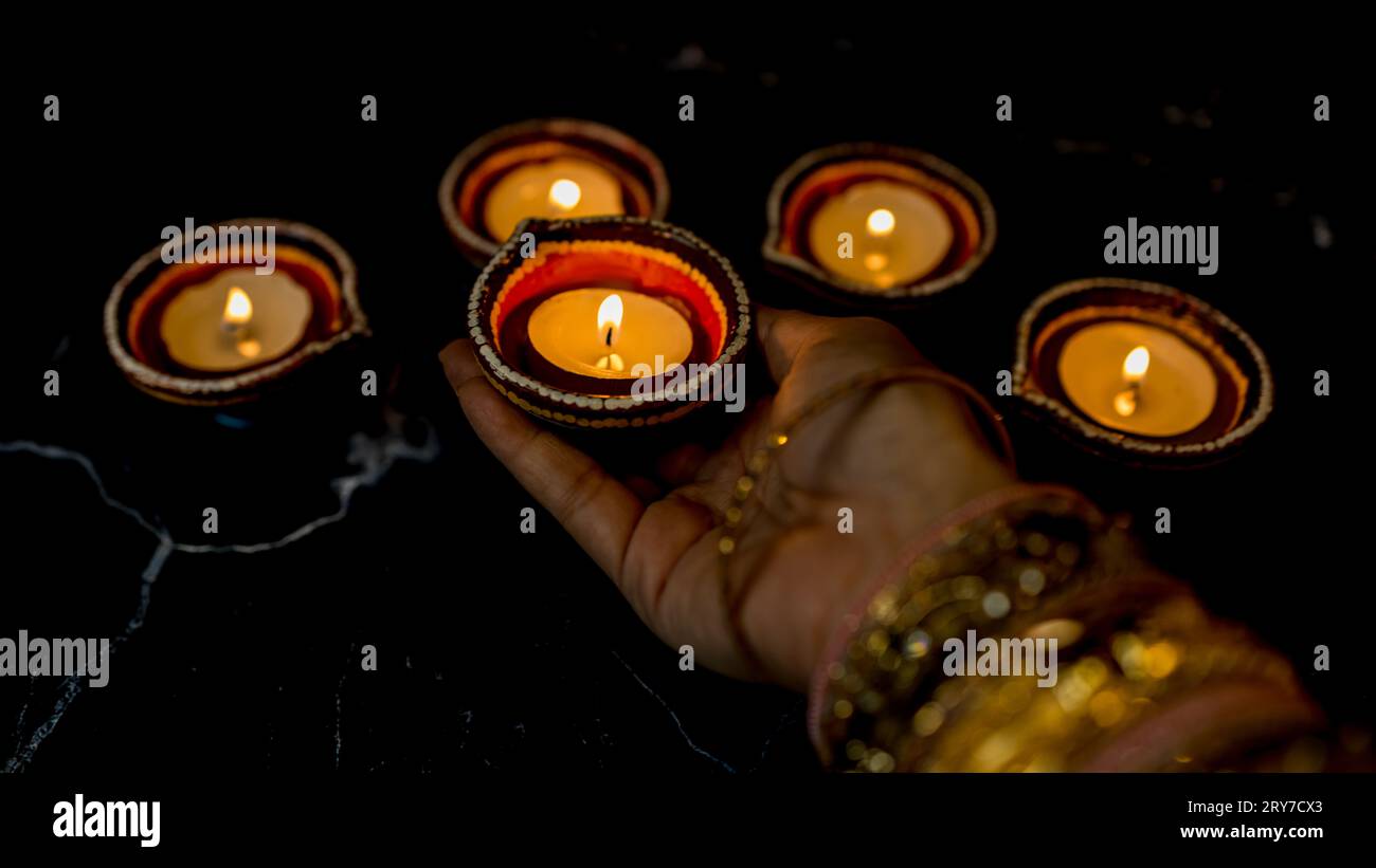 Happy Diwali - Woman hands with henna holding lit candle isolated on ...