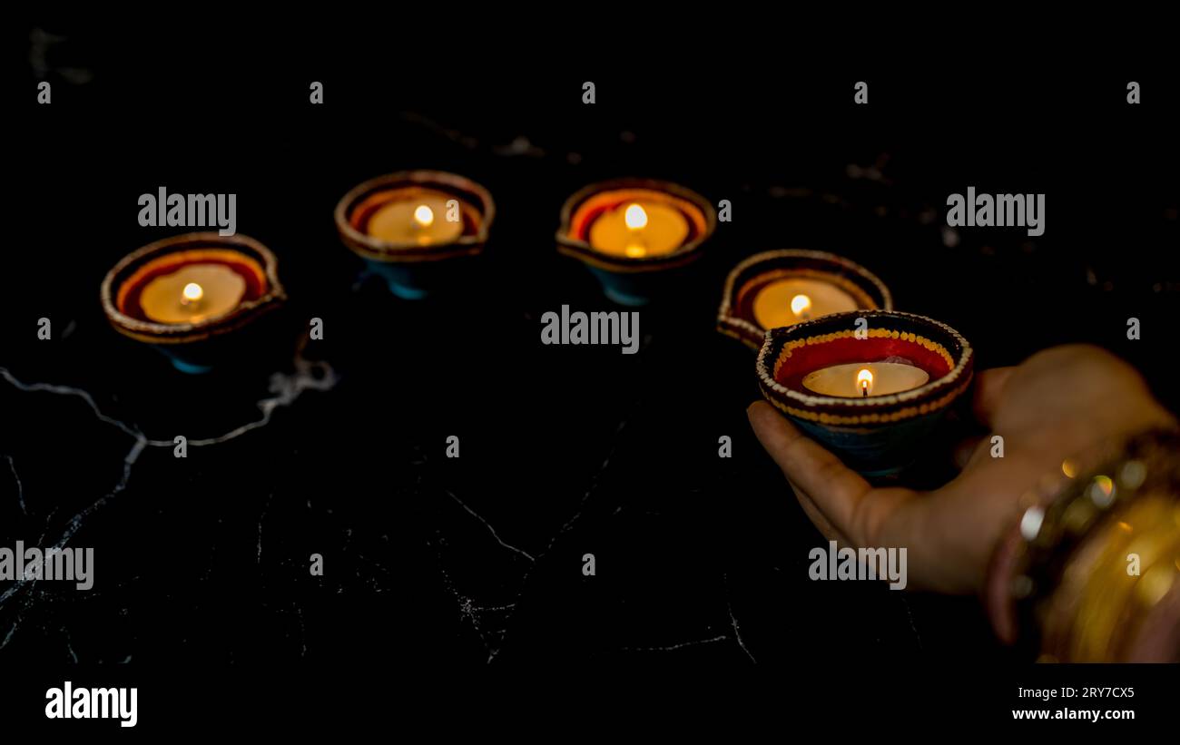 Happy Diwali - Woman hands with henna holding lit candle isolated on ...